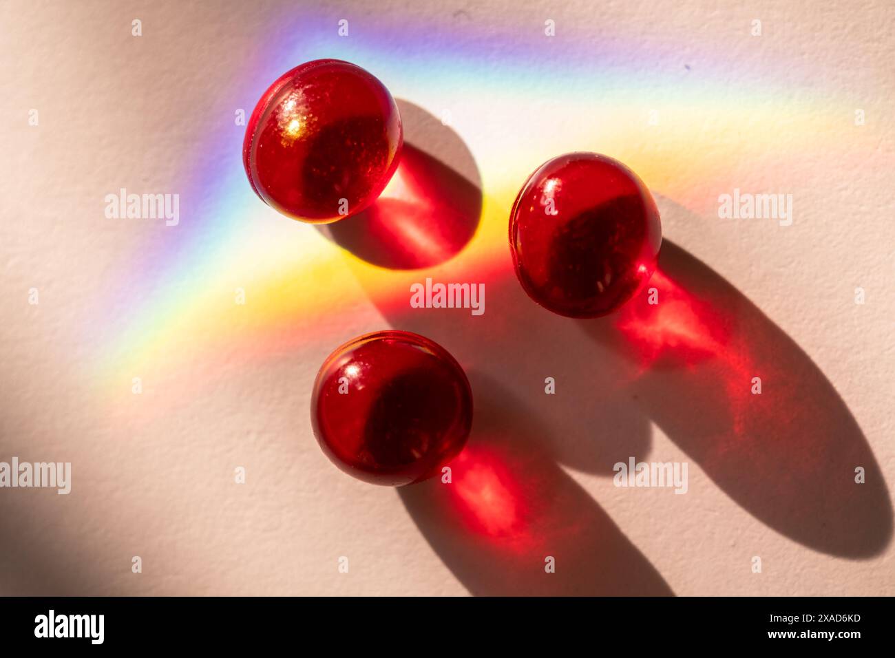 Capsules of red color with vitamin E on a light background and ...