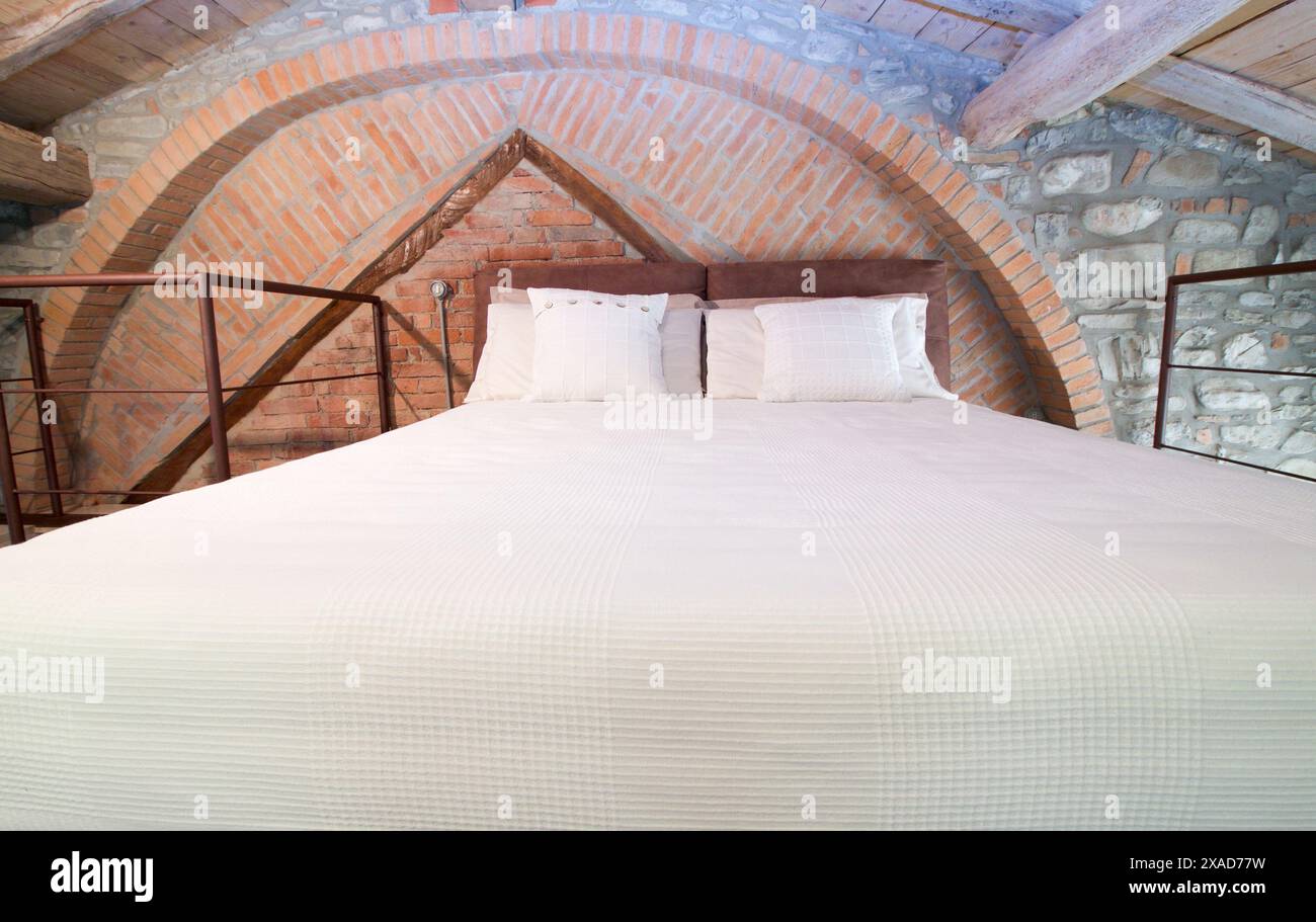 front view of king size bed on a mezzanine in a rustic loft Stock Photo ...