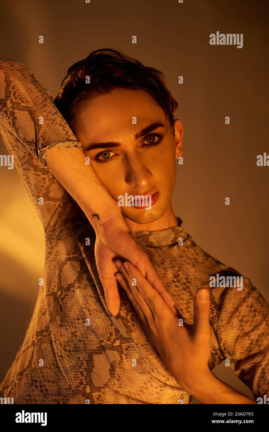 A young queer person confidently poses in a python skin dress ...