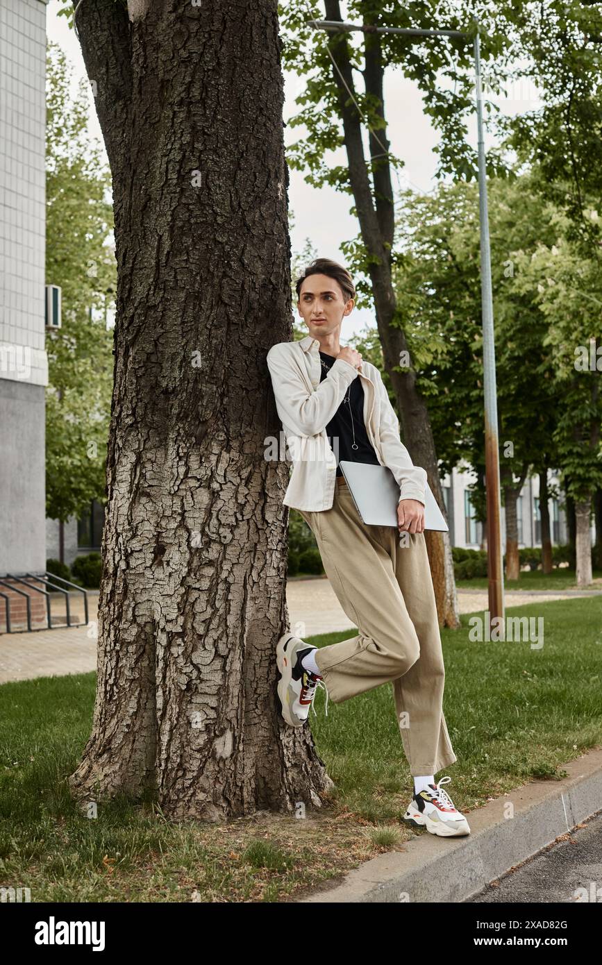 A young queer individual in stylish attire leans thoughtfully against a ...