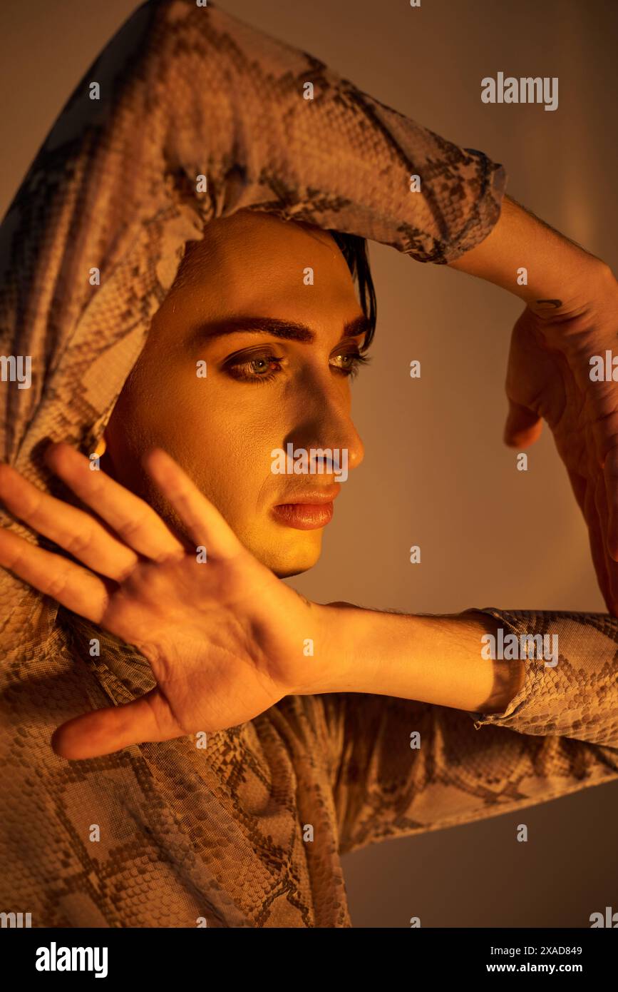 A young queer person in stylish attire strikes a powerful pose with ...