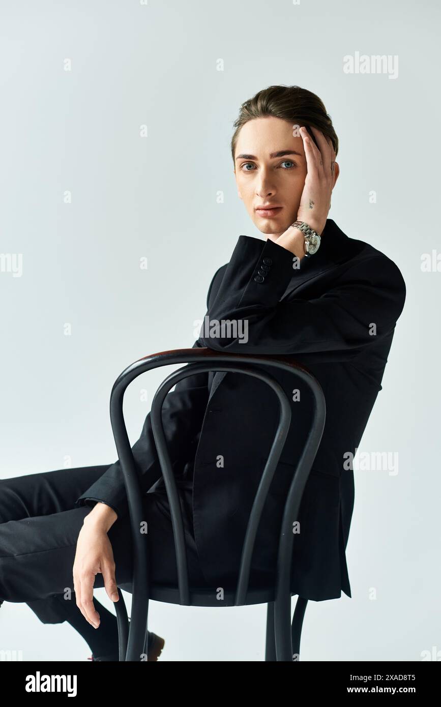 A young queer person exuding confidence, sitting on a chair in a ...