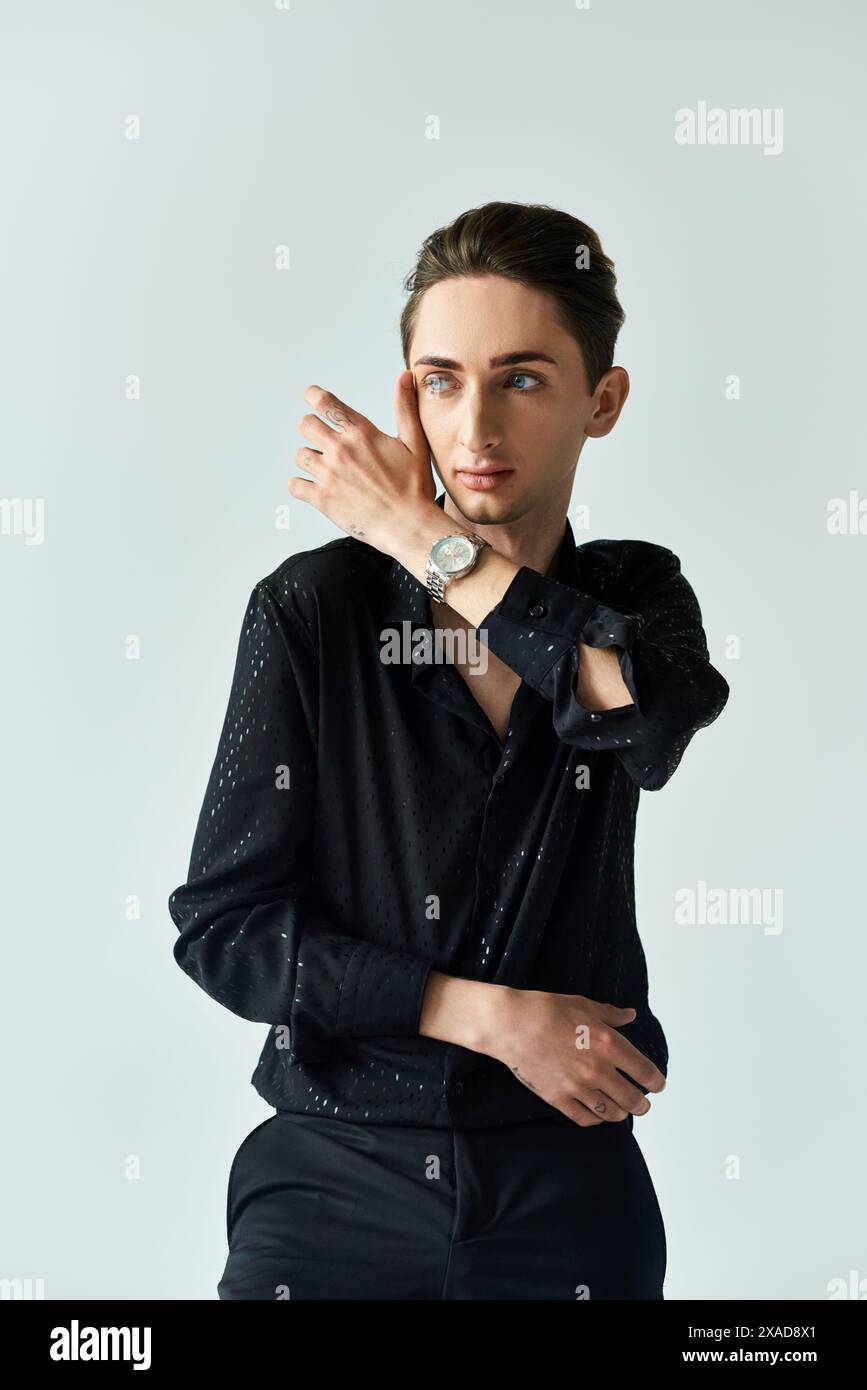 A young man in a black shirt exudes confidence while posing in a studio ...