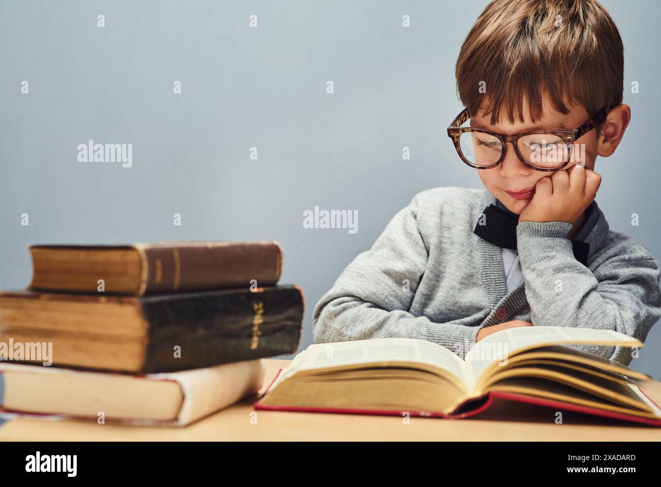 Boy, learning and books in studio for reading, glasses and education ...