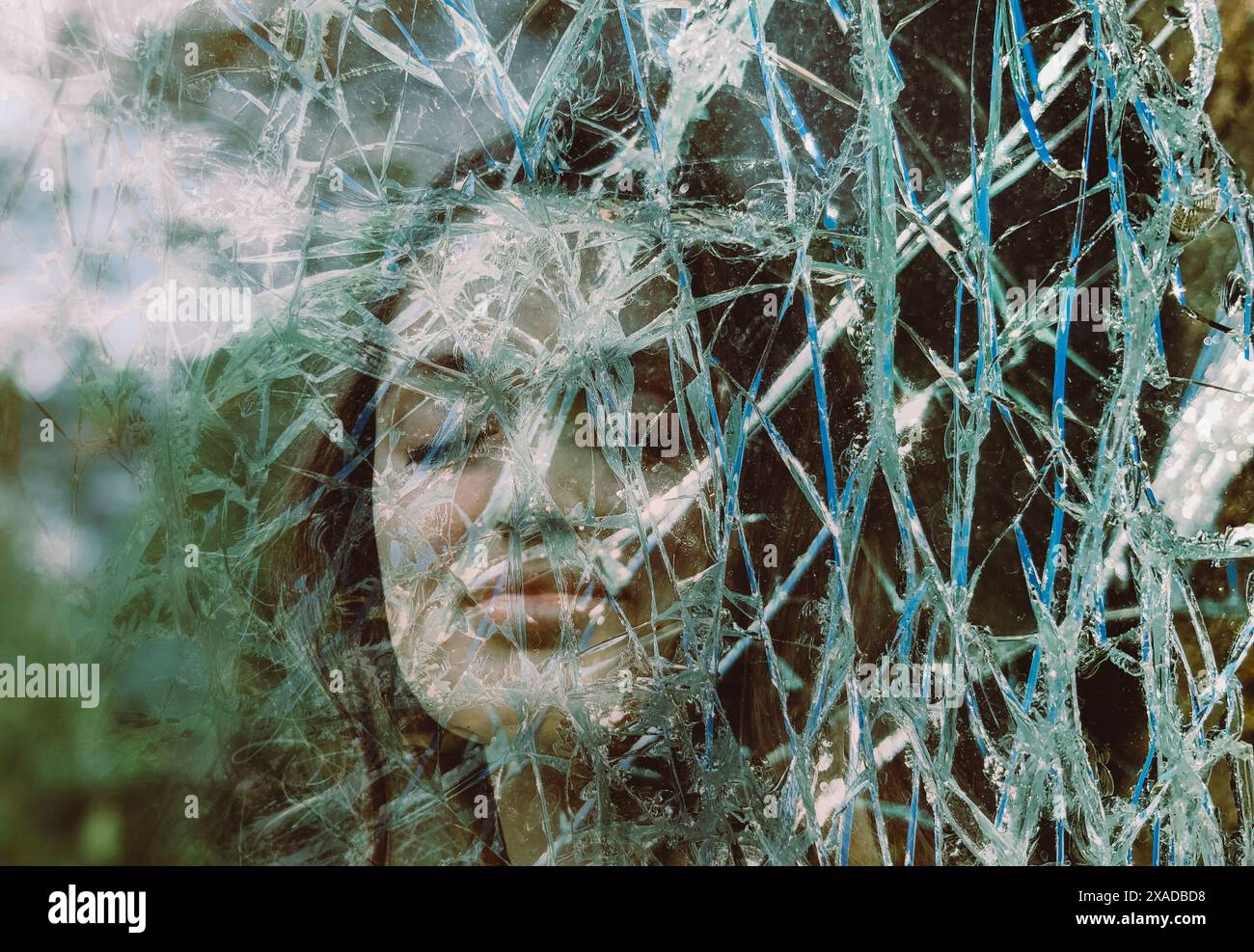 calm woman face with closed eyes behind the texture of a broken glass ...