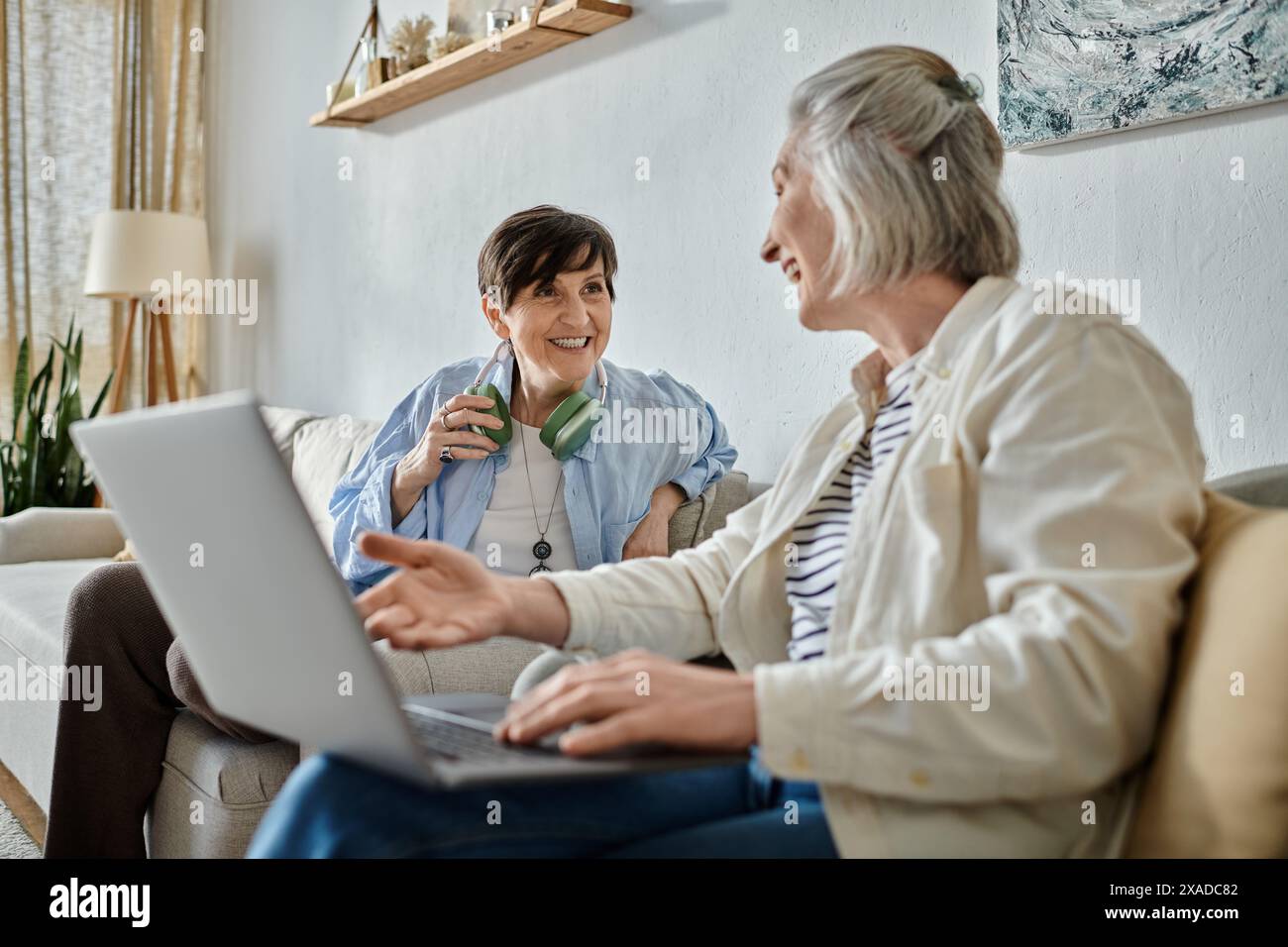Two women engage in a deep conversation on a laptop while seated on a ...
