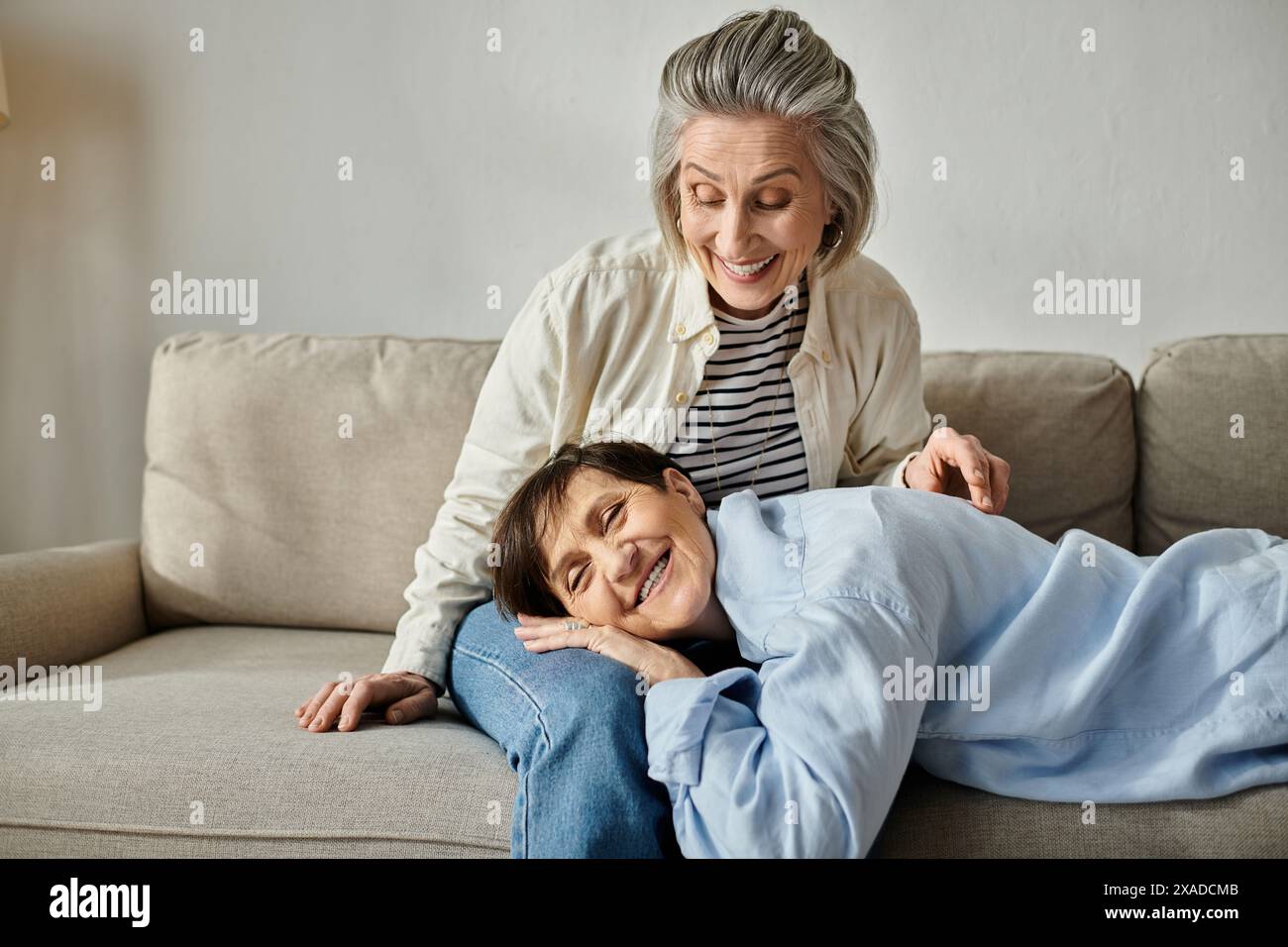 Two women peacefully laying together on a couch Stock Photo - Alamy