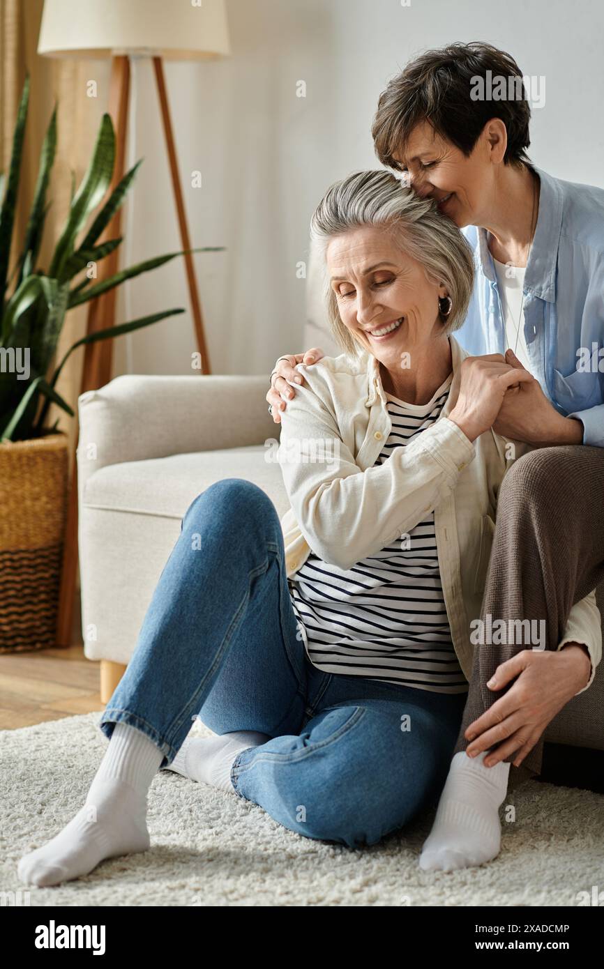 Two elderly women sharing a heartfelt hug on the floor Stock Photo - Alamy