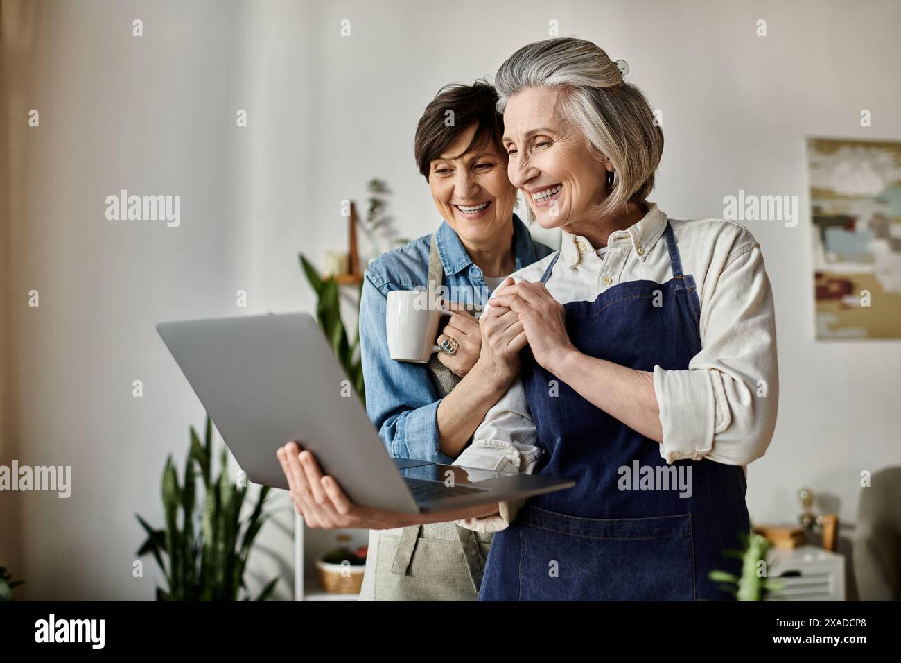 Two women engaged with laptop together Stock Photo - Alamy