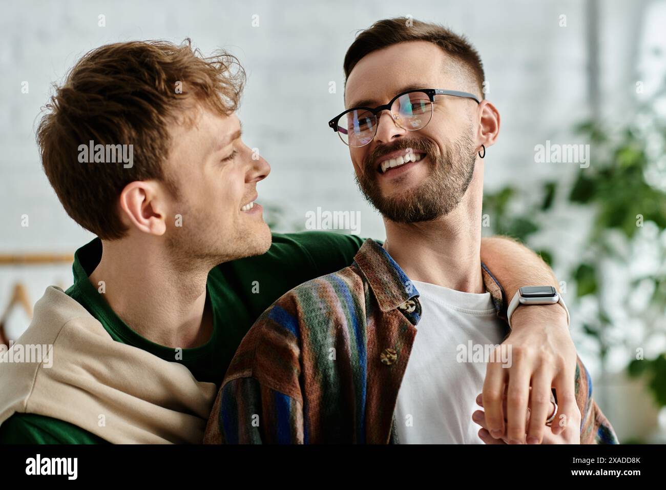 Two men sit closely in a designer workshop, passionately creating ...