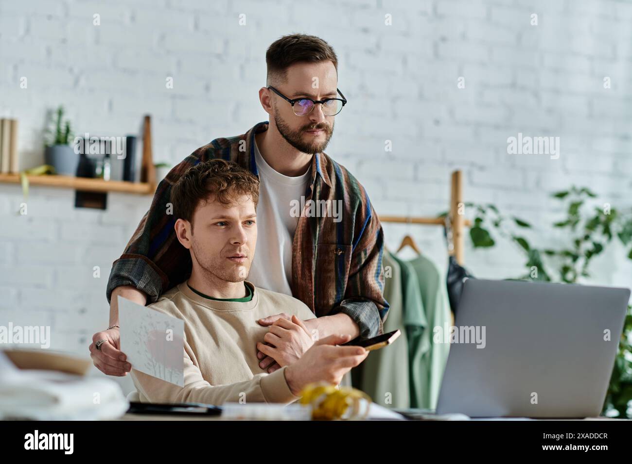 men with laptop in front, designing trendy attire in designer workshop ...