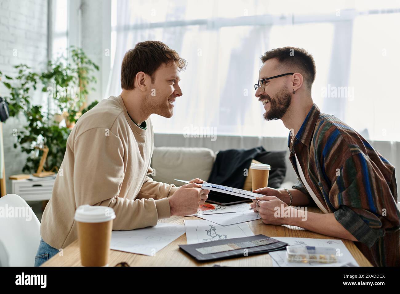 Two creative designers discussing ideas over a table in a trendy ...