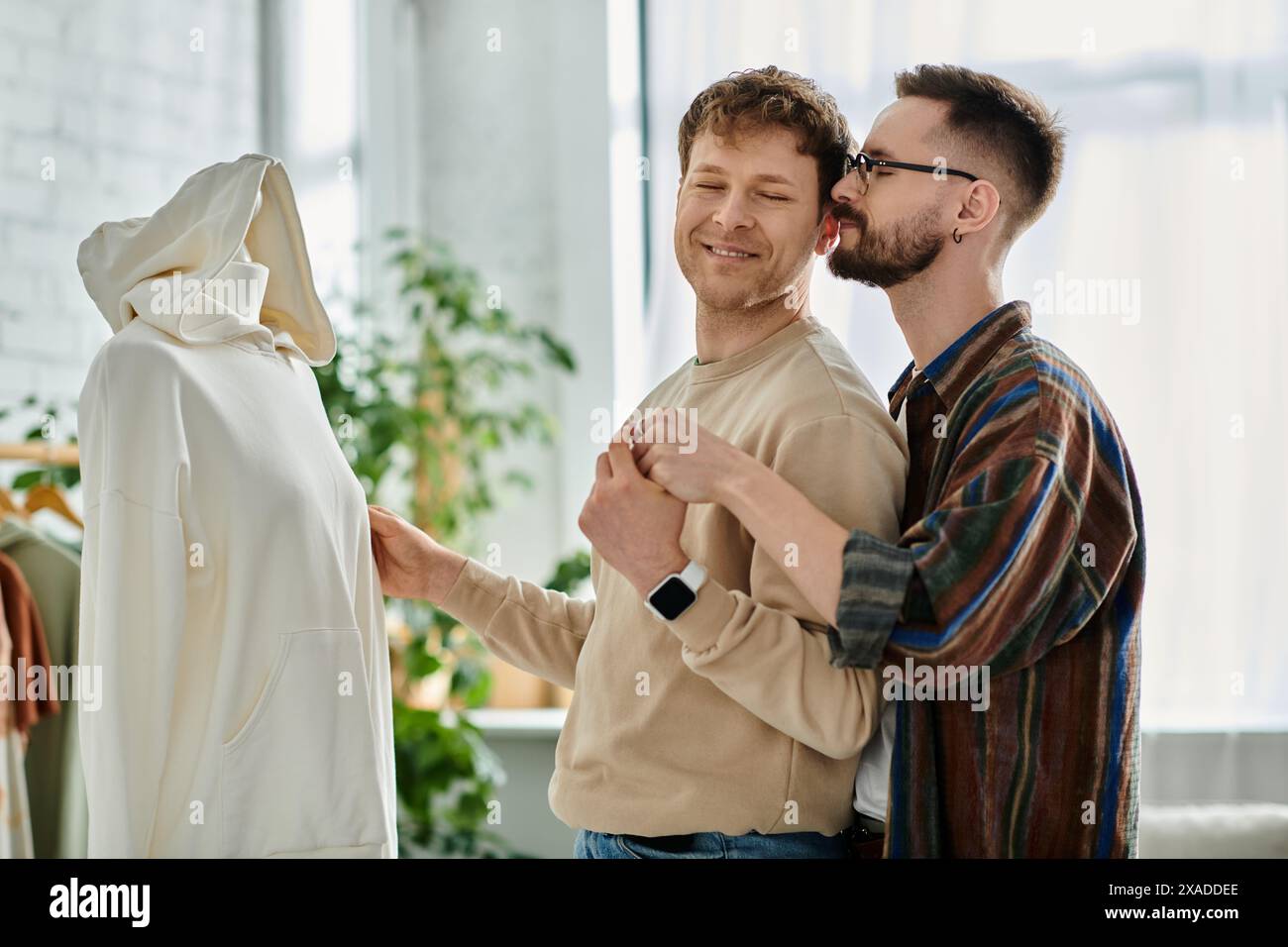 A gay couple stands together in a designer workshop, collaborating on ...