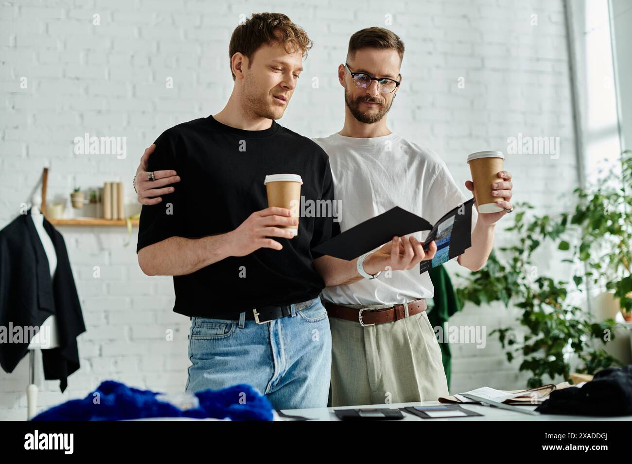 Two men, part of a stylish design duo, enjoy a coffee break together ...