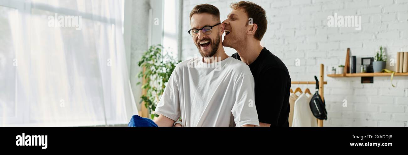 Two fashion designers embrace in their atelier, having fun, sharing ...