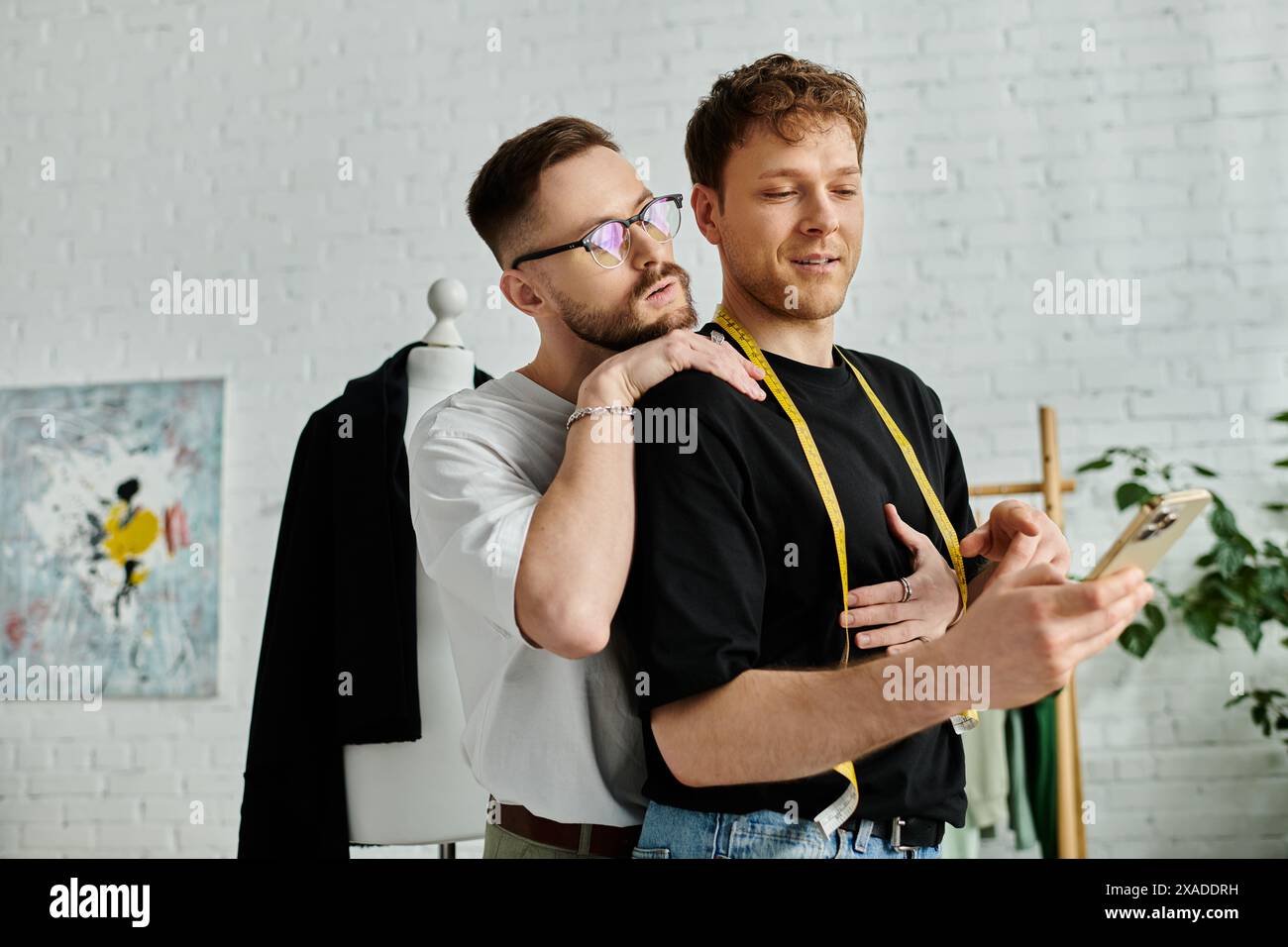 Two men, fashion designers, stand side by side in their workshop Stock ...