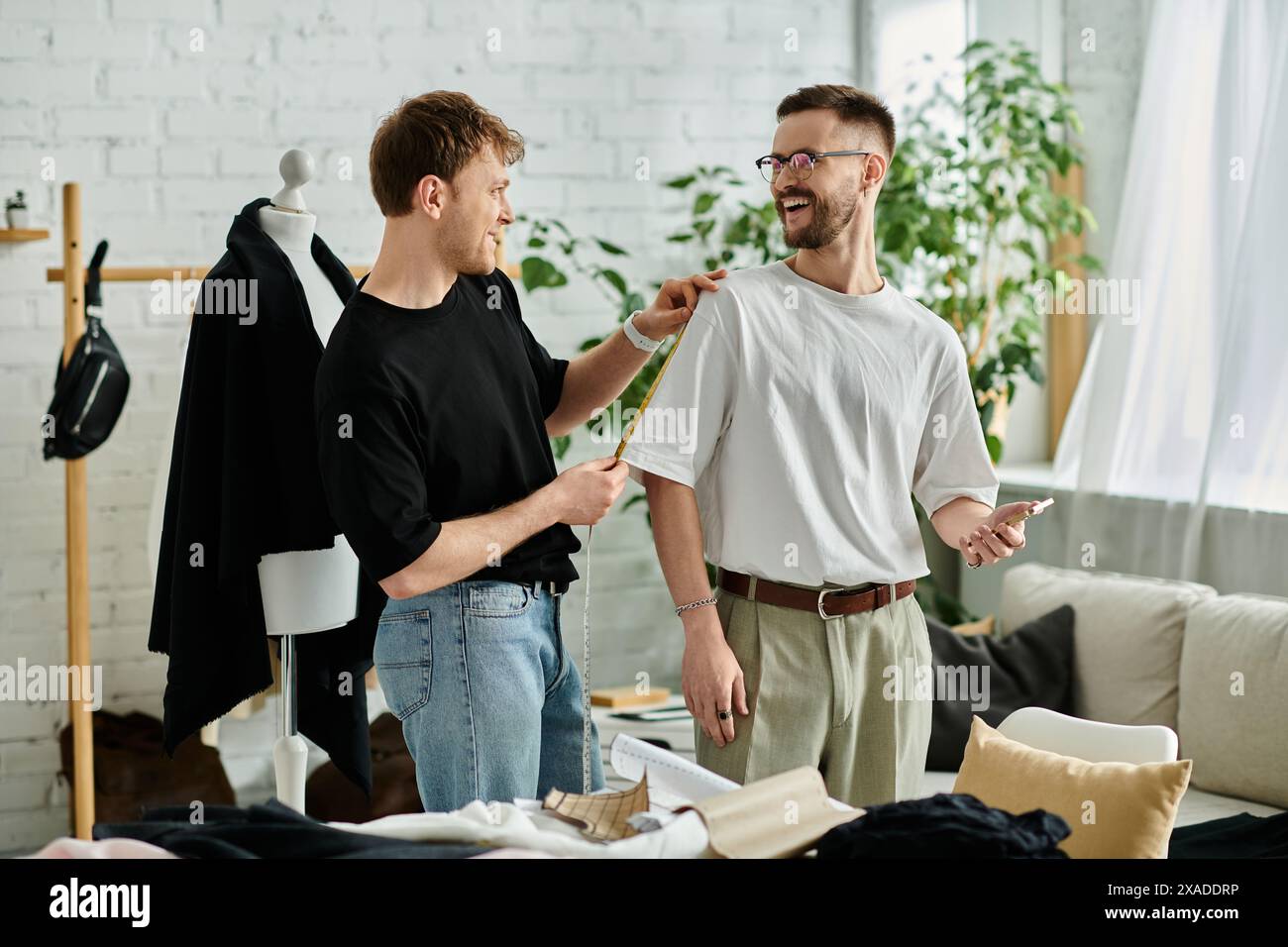 Two men in a designer workshop, working on stylish attire together ...