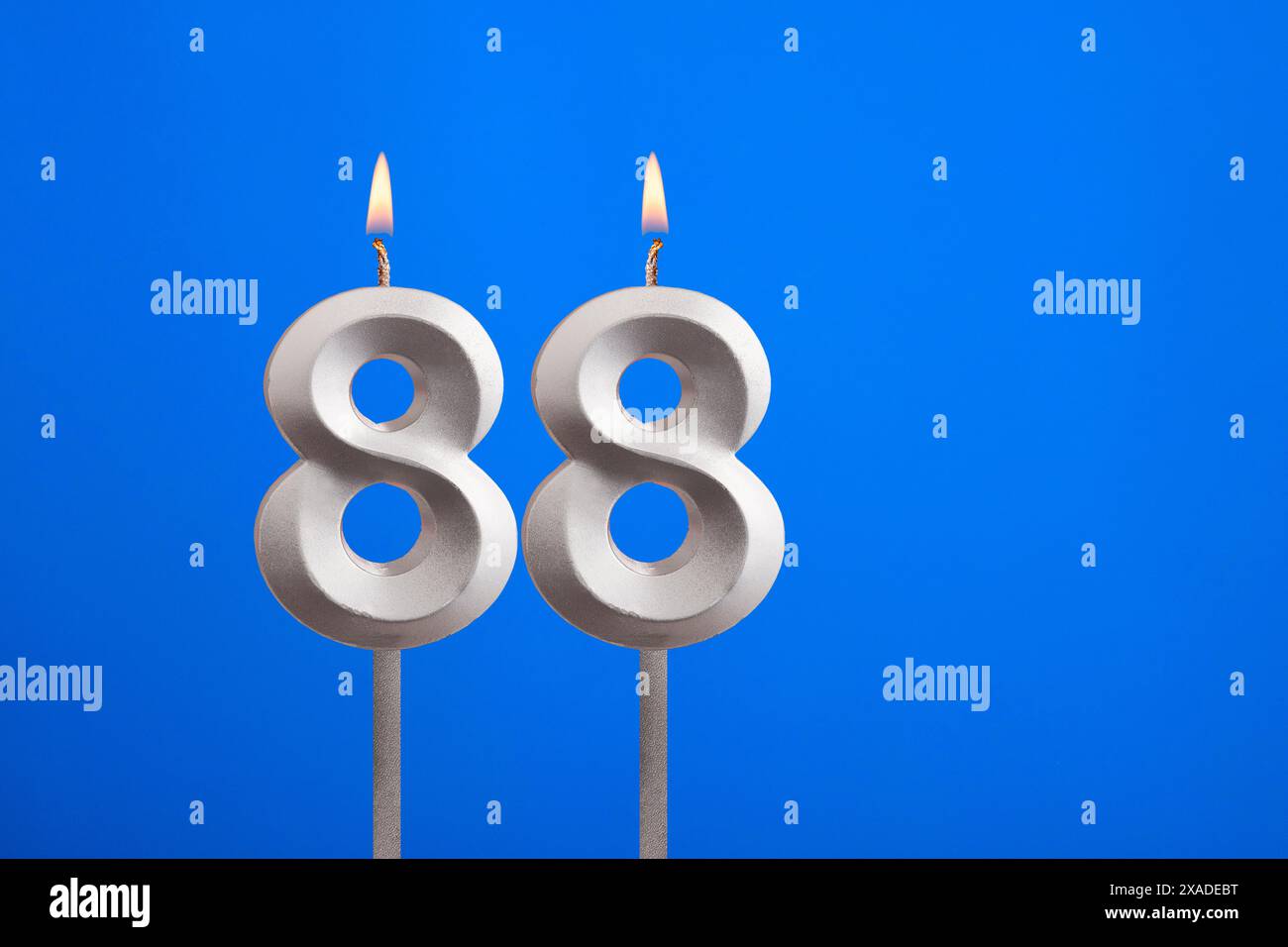 Birthday number 88 - Candle lit on blue background Stock Photo - Alamy