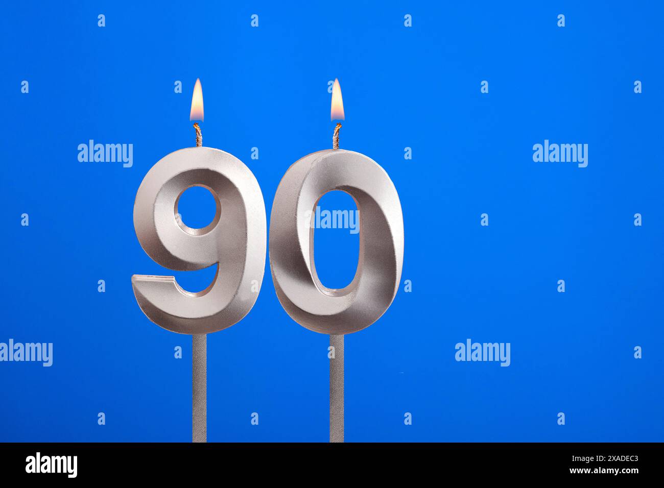Birthday number 90 - Candle lit on blue background Stock Photo - Alamy