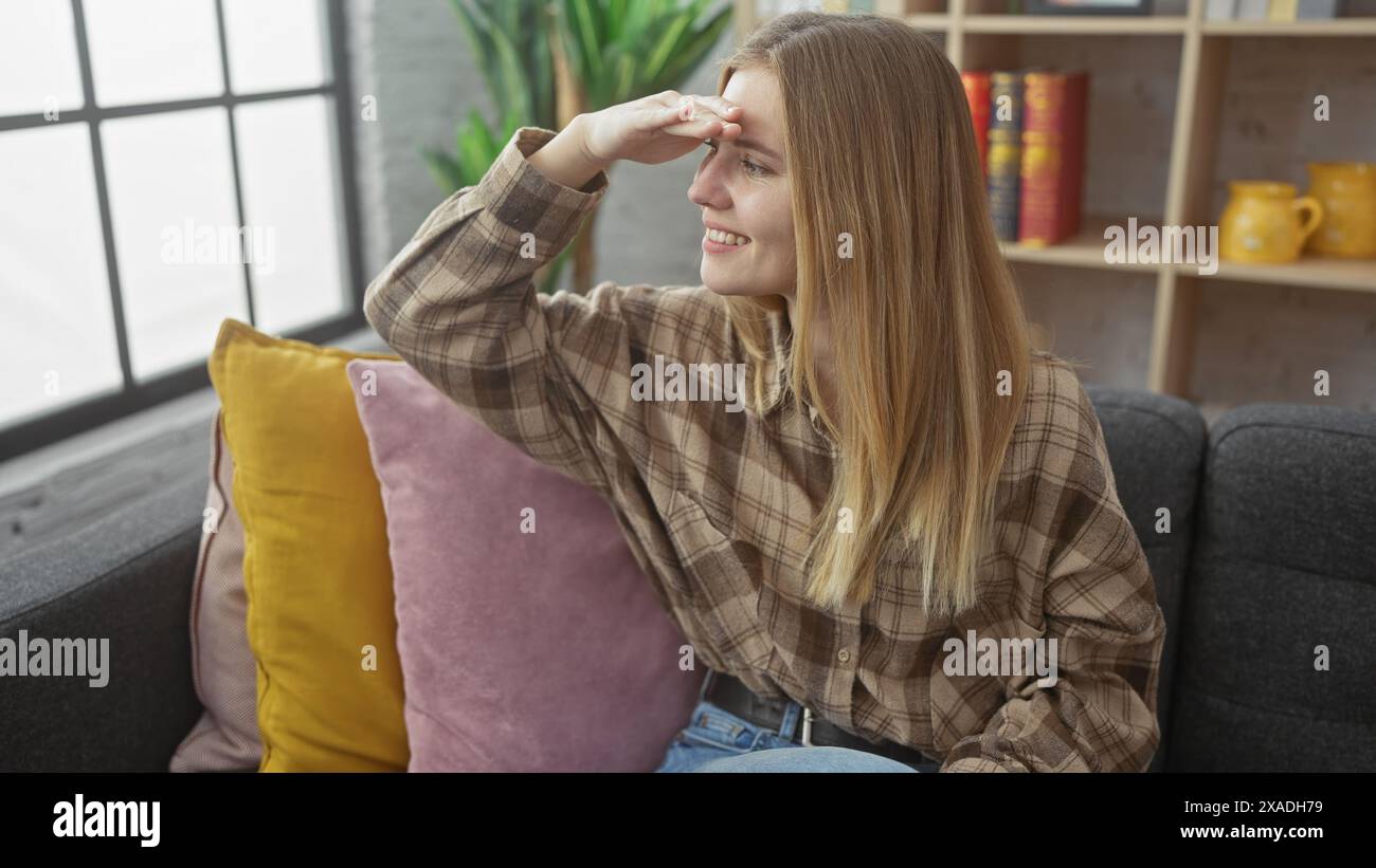 A young woman shading her eyes from bright light while sitting on a ...