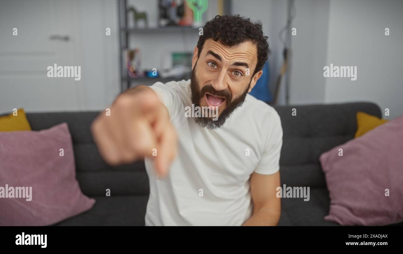 Angry bearded man pointing directly at the camera in a home interior ...
