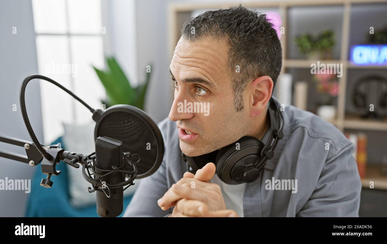 Hispanic man speaking into microphone in a radio studio, conveying ...