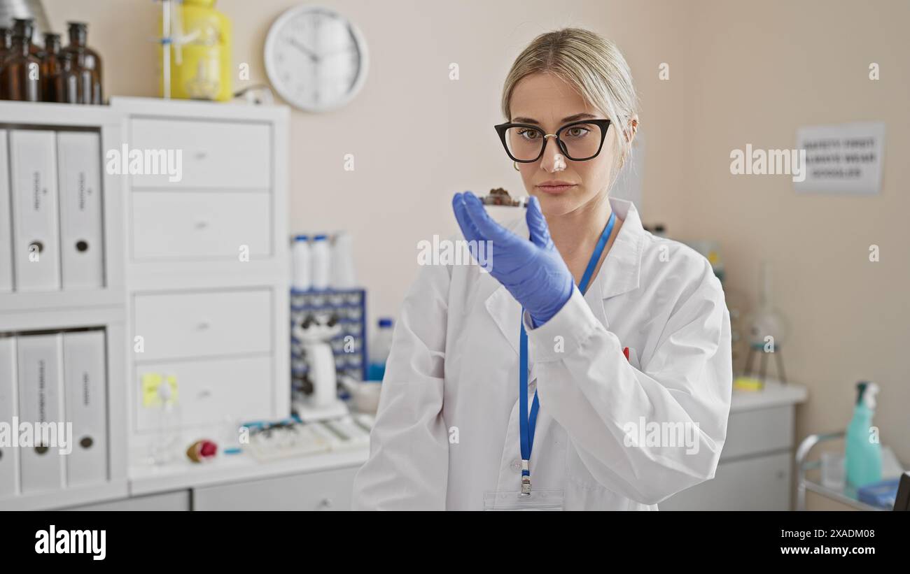 A focused young woman in a lab coat examines a specimen indoors at a ...