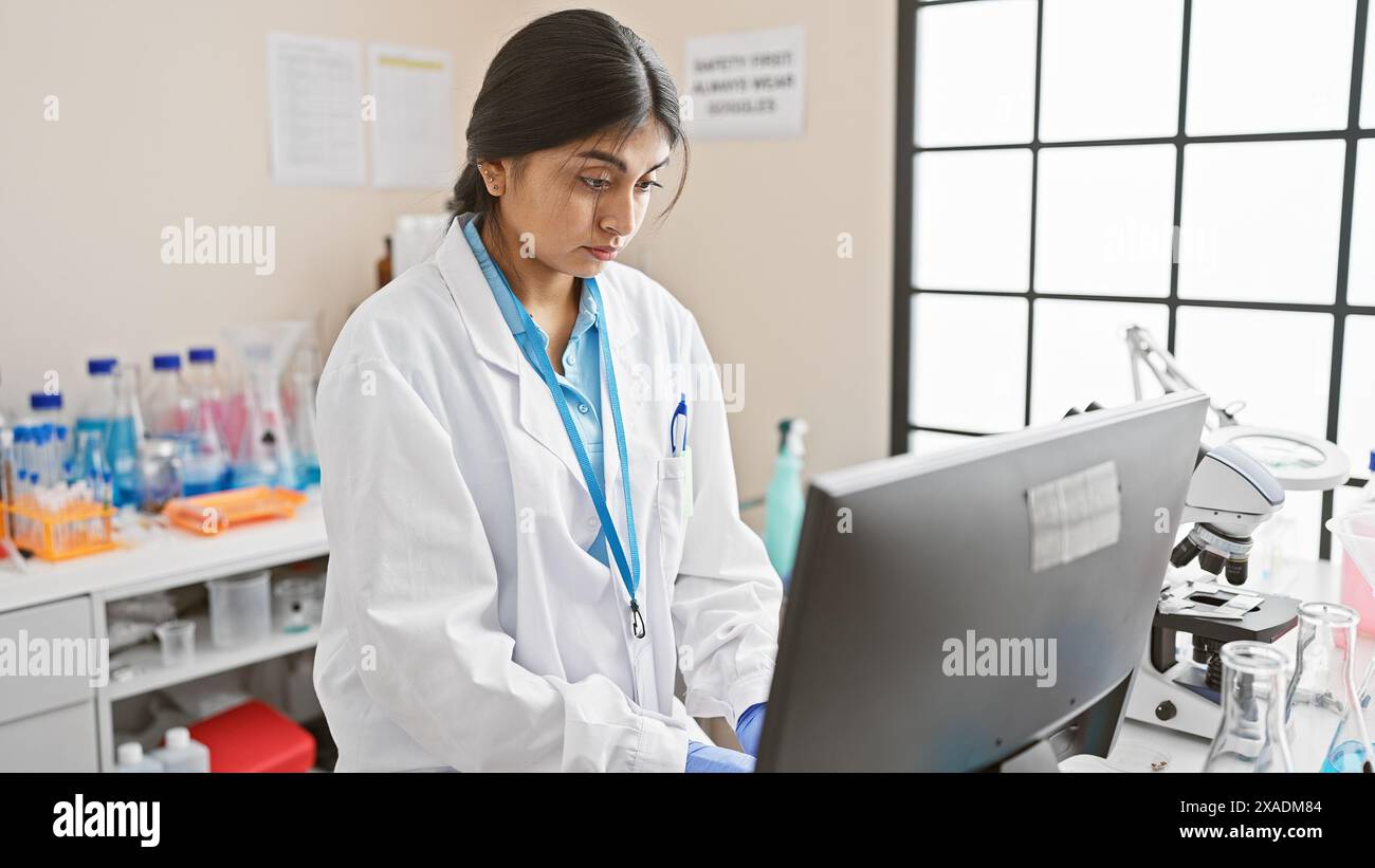 A focused indian woman scientist analyzes data on a computer in a laboratory setting Stock Photo ...
