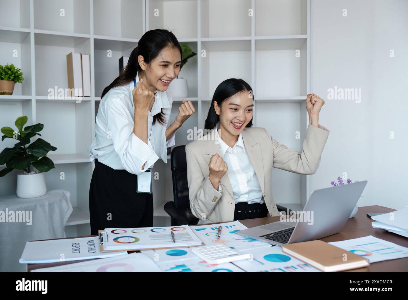 Two women are celebrating in a business setting Stock Photo - Alamy