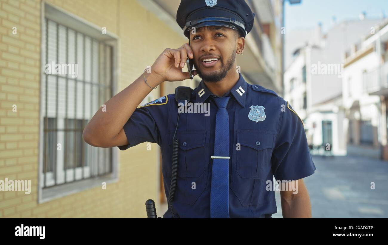 An african american police officer talking on his radio with a city ...