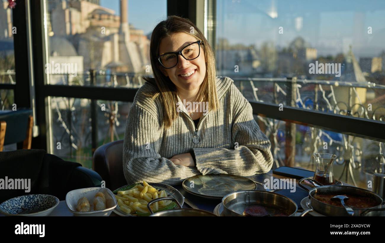A smiling woman enjoying a traditional turkish breakfast in a ...