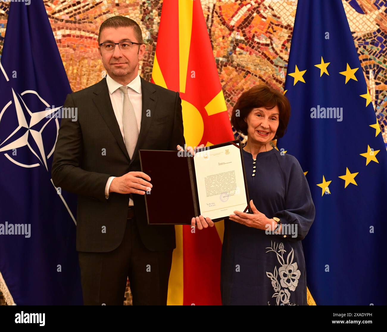 North Macedonia s President Gordana Siljanovska Davkova R hands over ...
