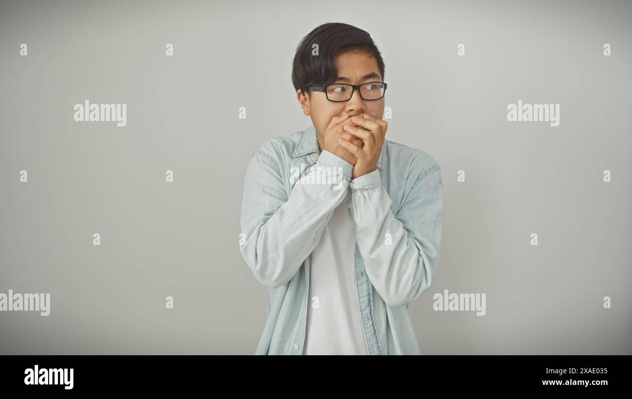 Surprised young asian man covering mouth with hands against an isolated white background Stock ...