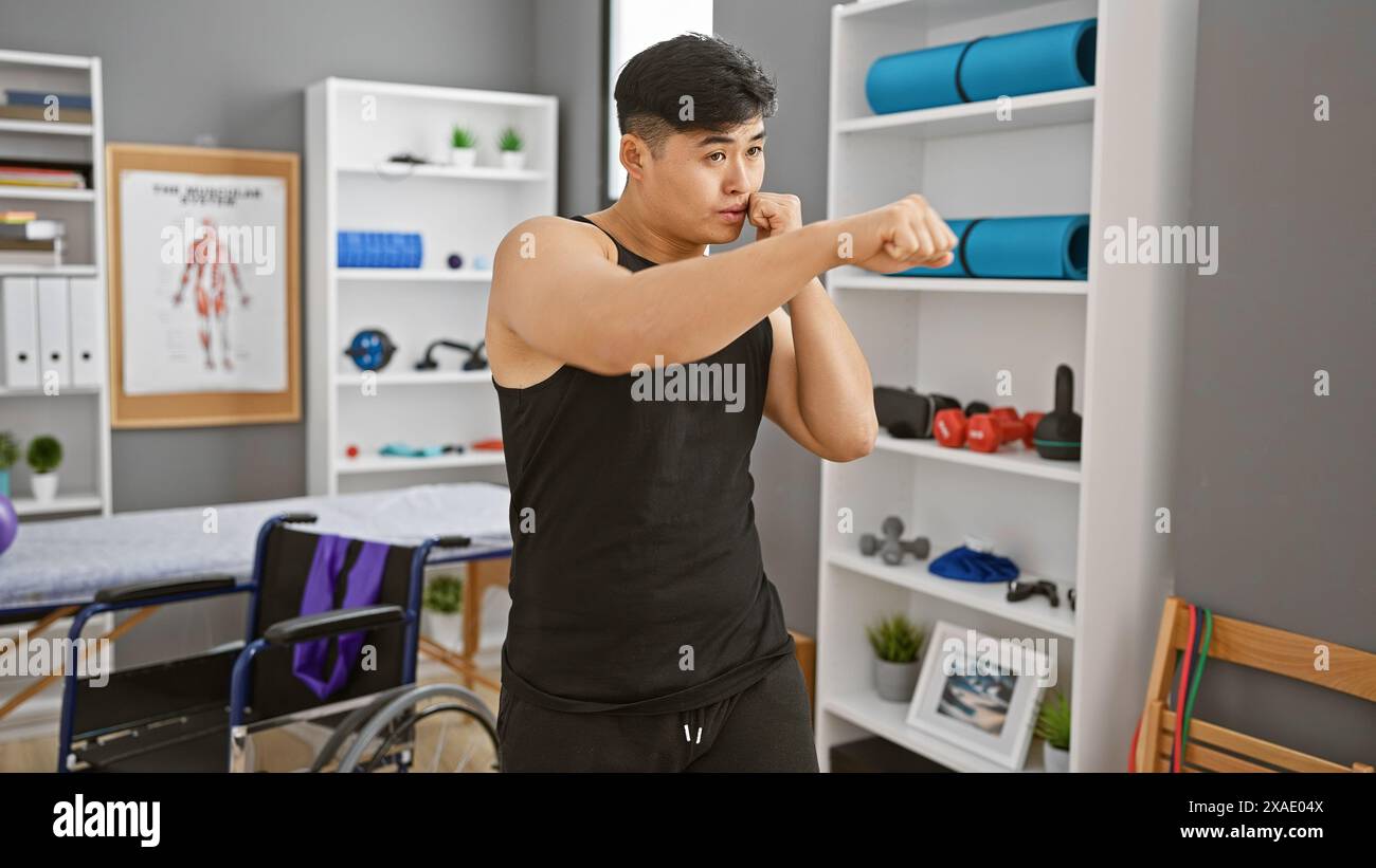 A young asian man exercising in a physiotherapy clinic's rehabilitation ...