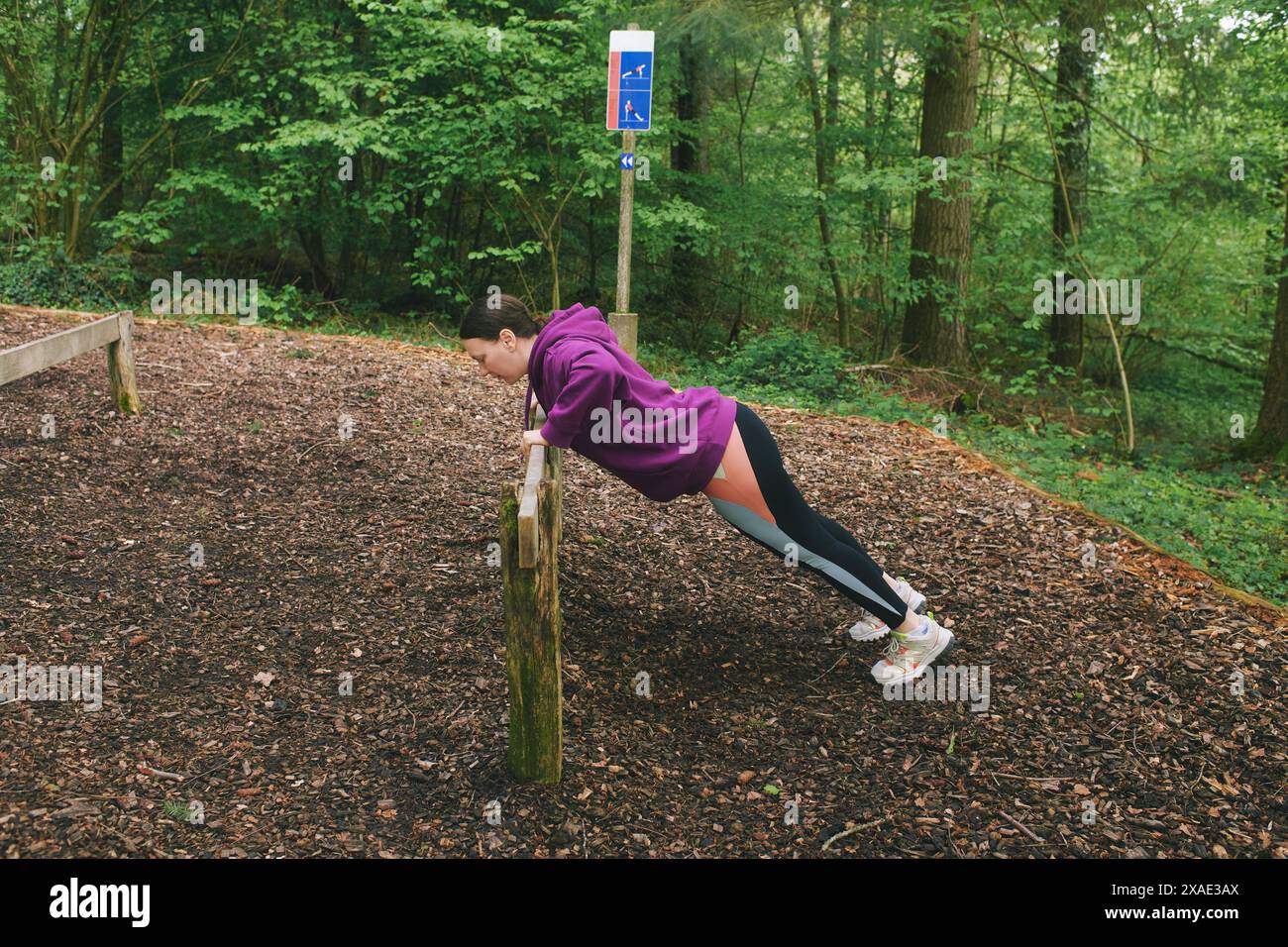 Outdoor portrait of happy middle age woman exercising with wooden ...
