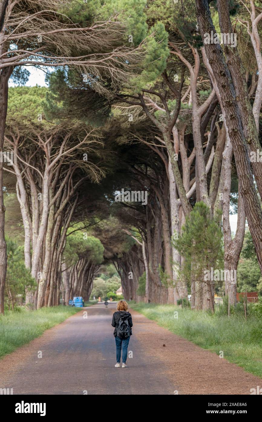 A blonde woman with a backpack walks along Viale del Gombo in the San ...