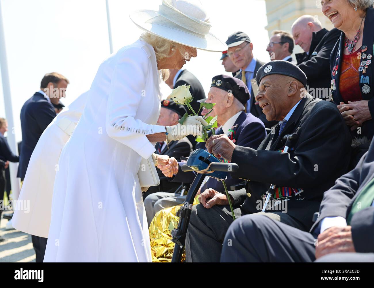 Queen Camilla receivers a white rose from D-Day veteran Gilbert Clarke ...