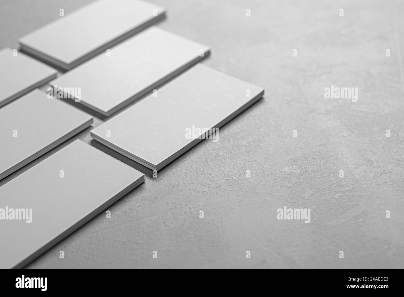 Blank business cards on light grey textured table, closeup. Mockup for ...