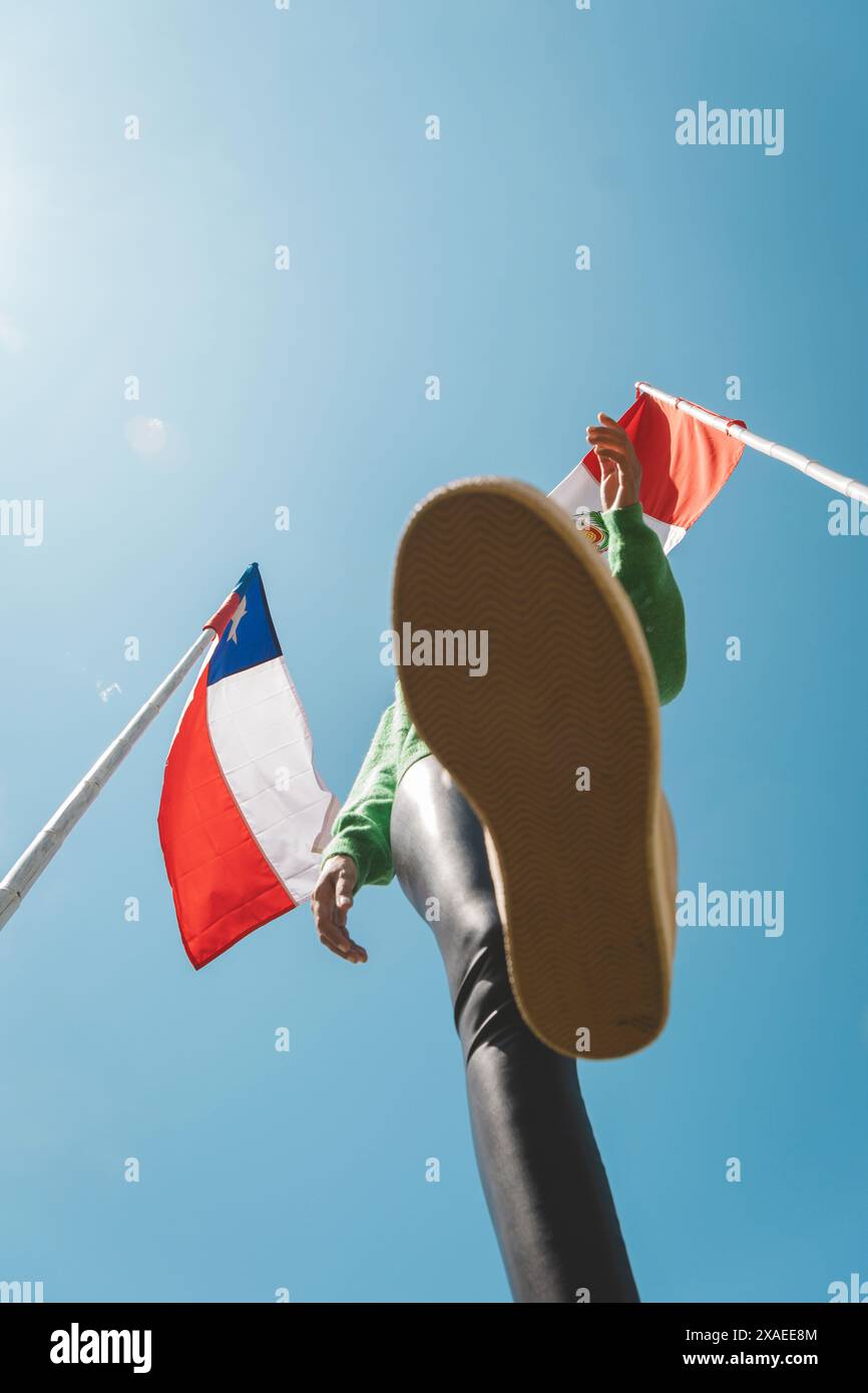 A woman at the border, the flags of Peru and Chile. Migration concept ...