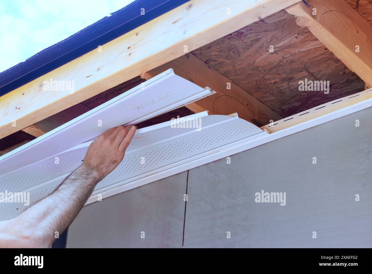 Installation of upvc soffit boards at roof corner of home rafters ...