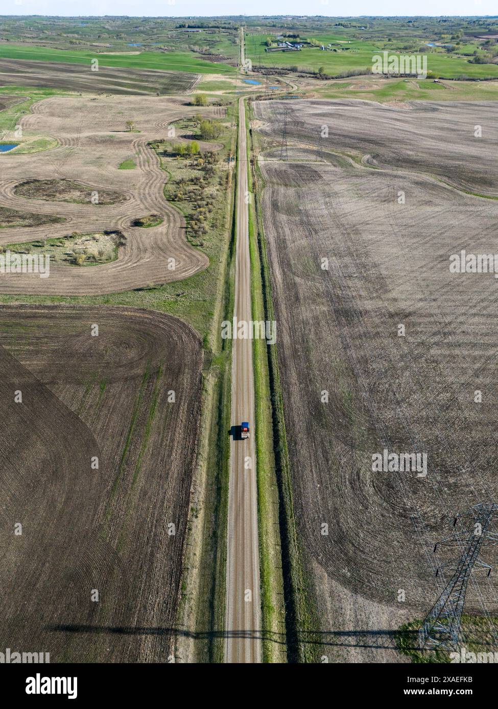 Aerial car driving down country road overlooking agriculture lands and ...