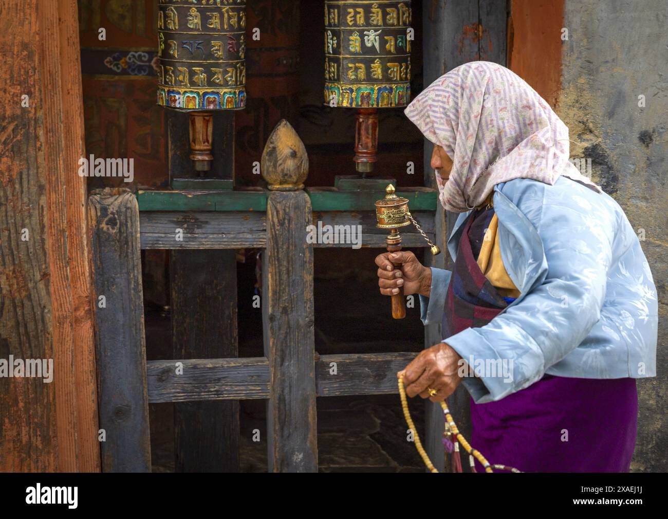 Bhutanese woman with prayer wheels in Jamphel Lhakhang, Chhoekhor Gewog ...