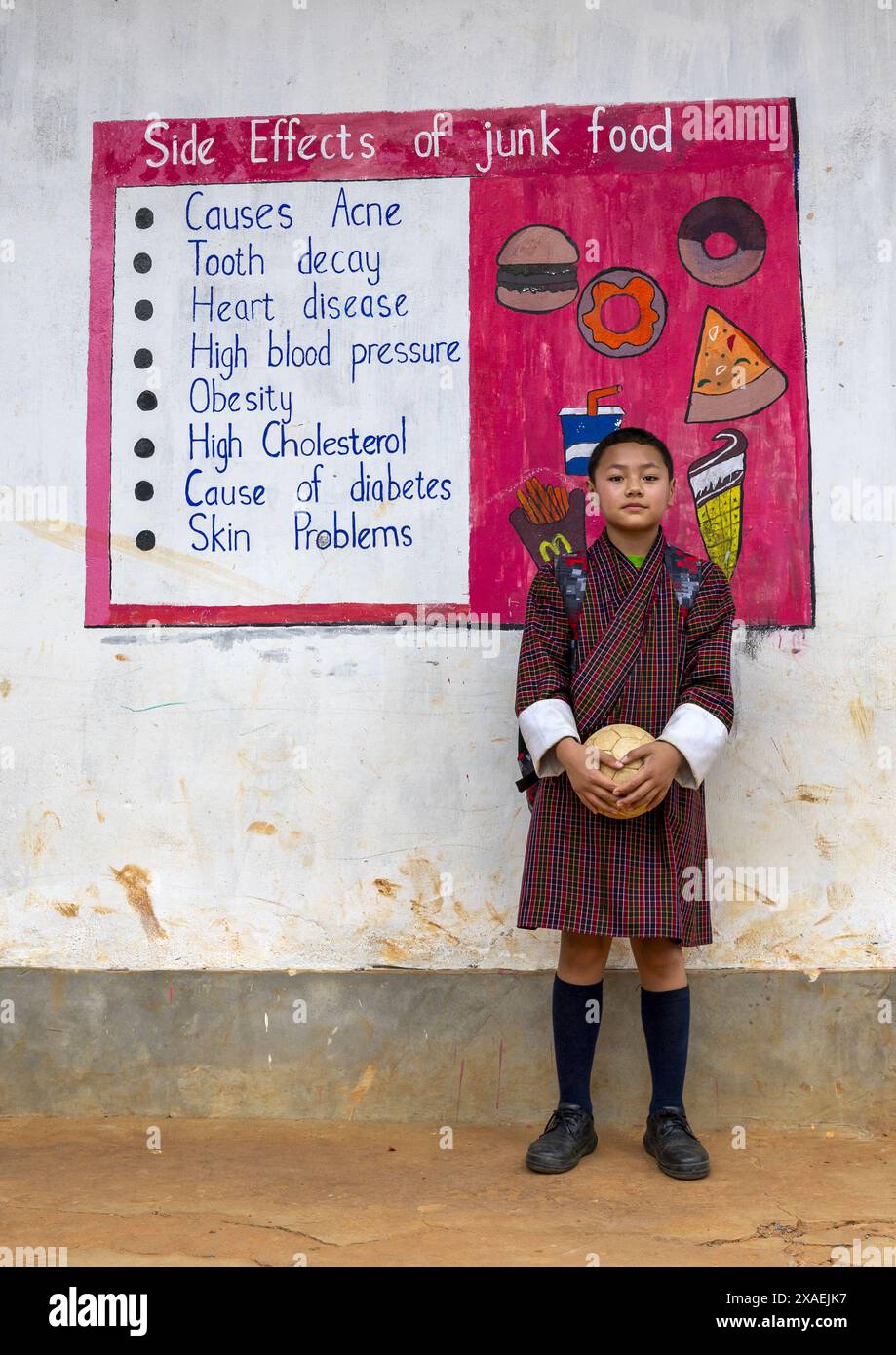 Portrait of a boy in front of a junk food mural in Rubesa Primary ...