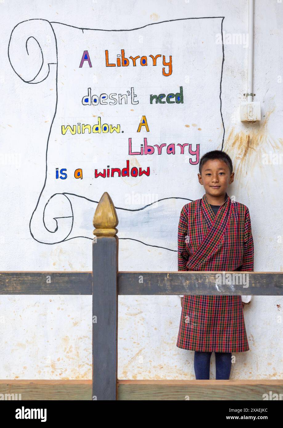 Portrait of a boy in front of a mural promoting books in Rubesa Primary ...