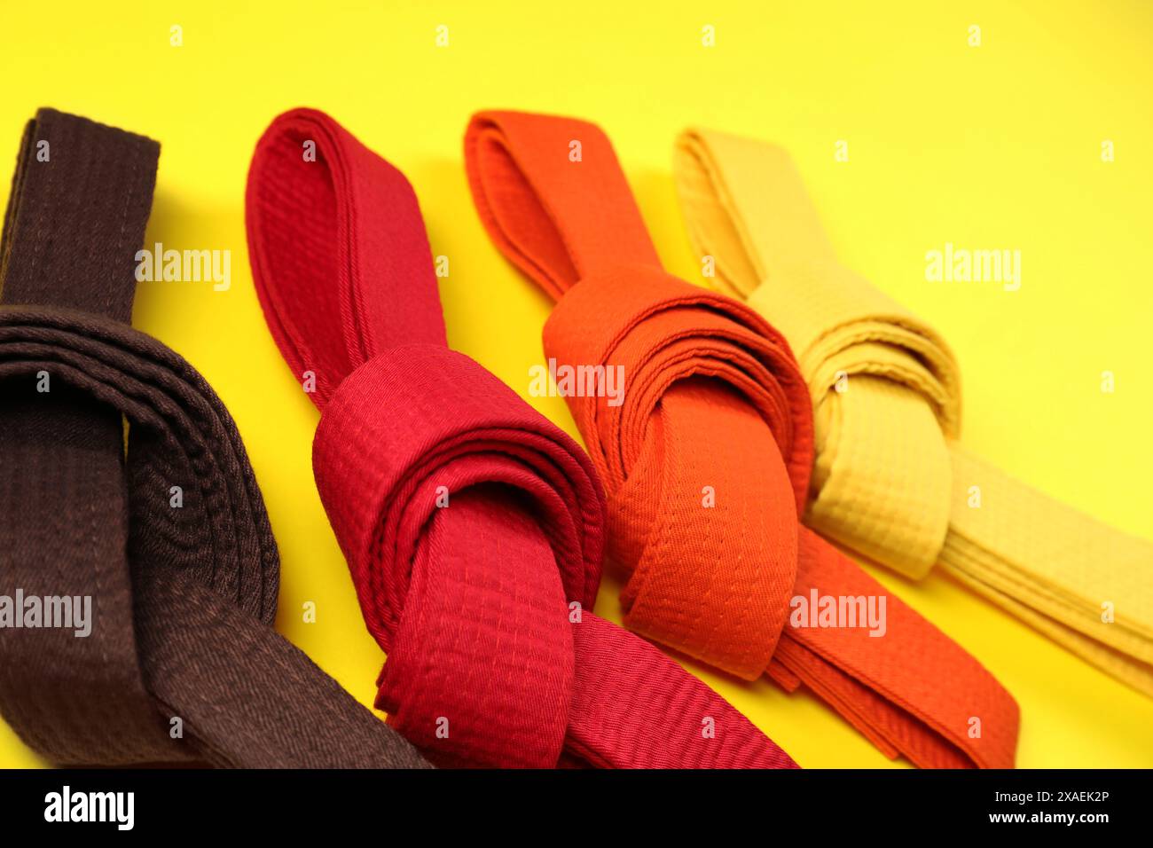 Colorful karate belts on yellow background, closeup Stock Photo - Alamy