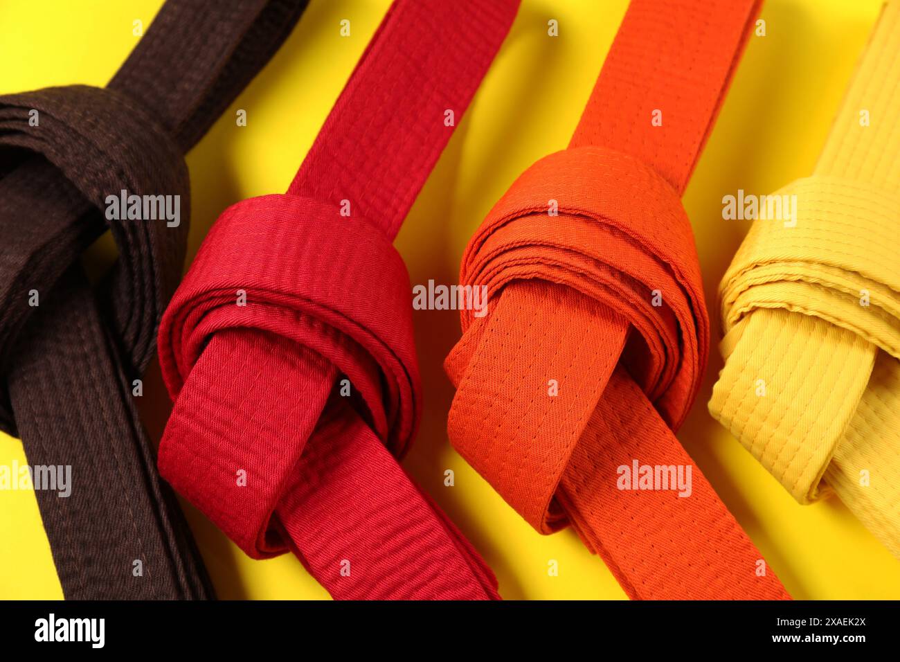 Colorful karate belts on yellow background, closeup Stock Photo - Alamy