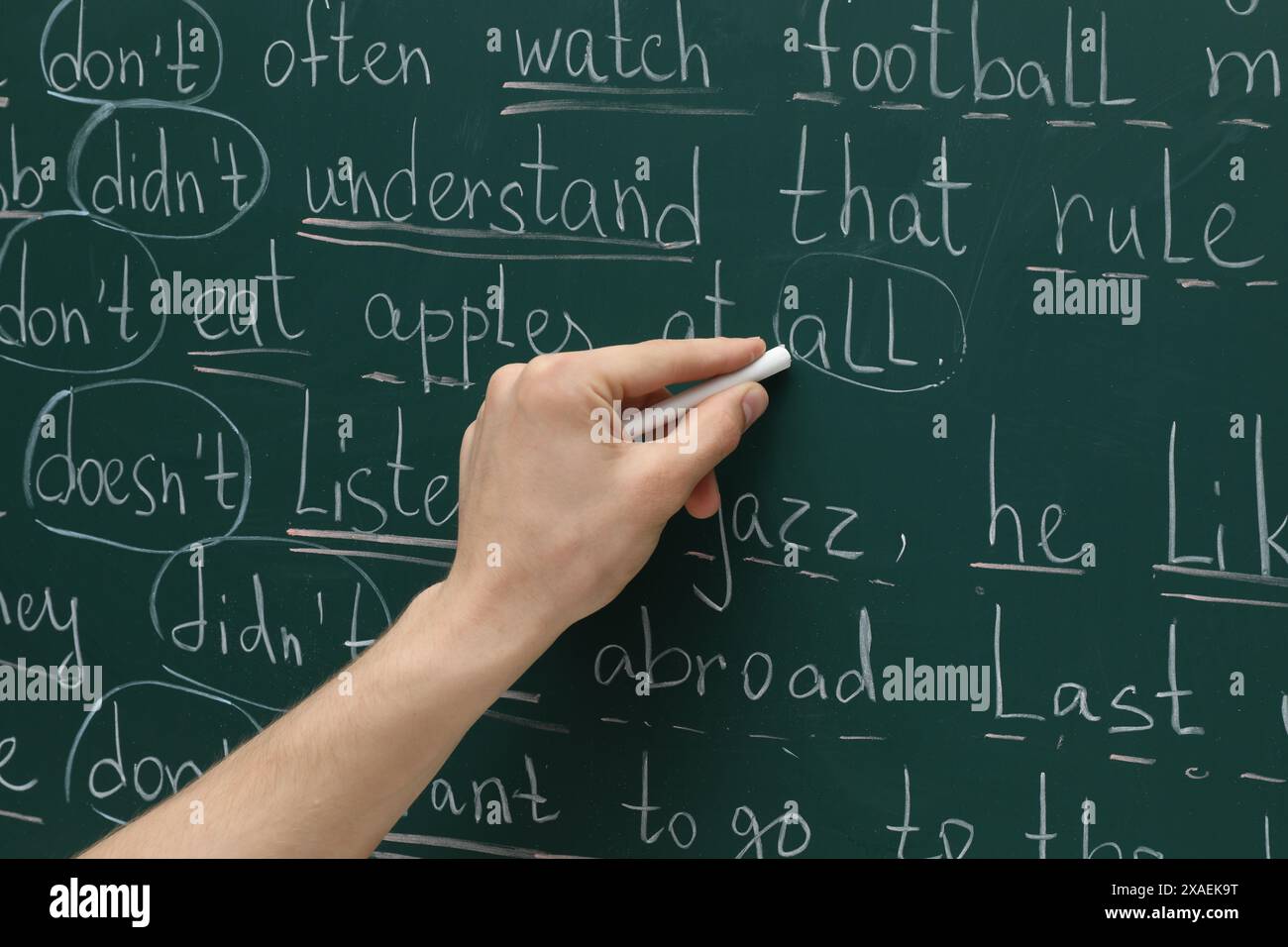 English teacher writing with chalk on green chalkboard, closeup Stock ...