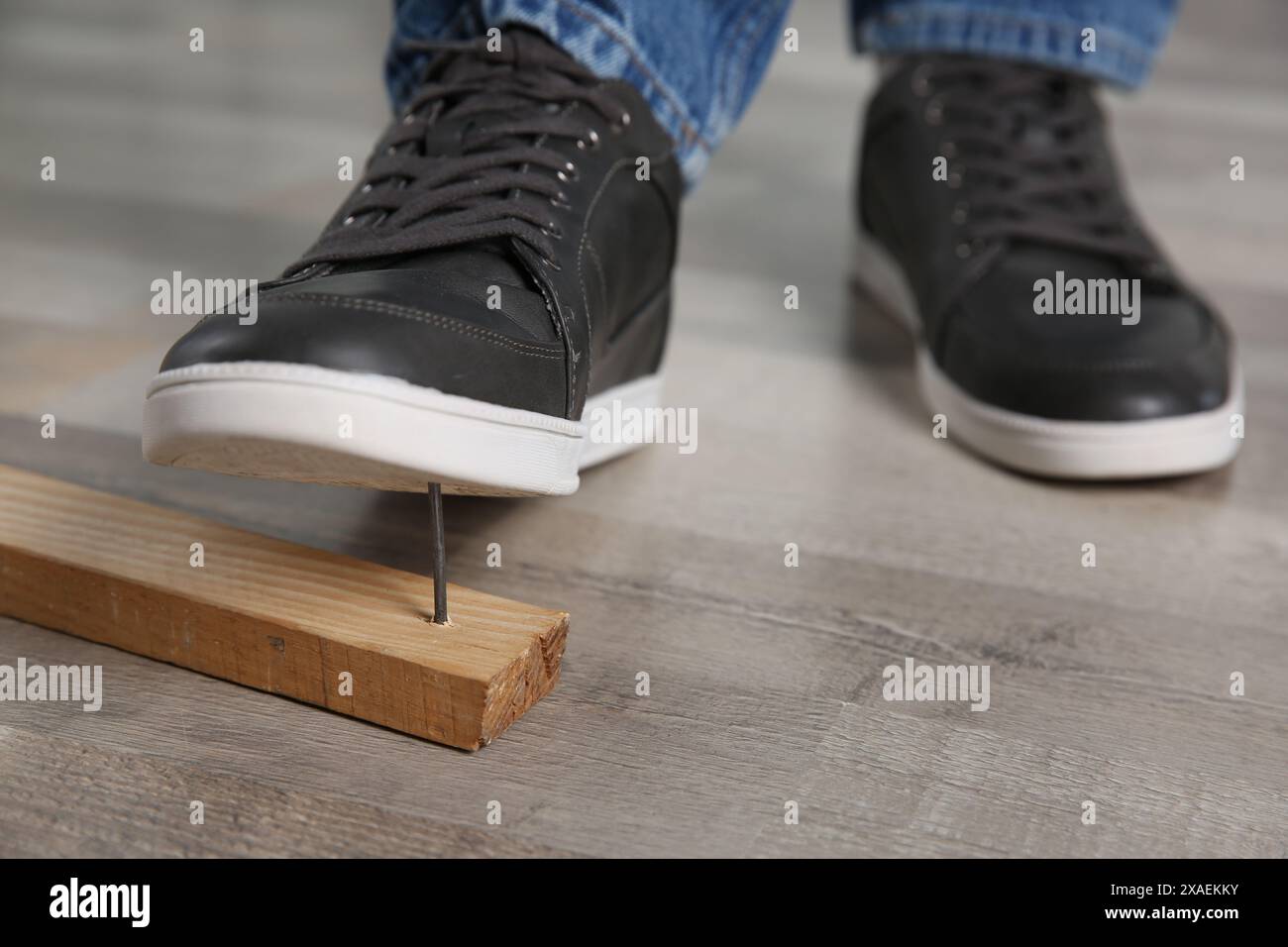 Careless man stepping on nail in wooden plank, closeup Stock Photo - Alamy