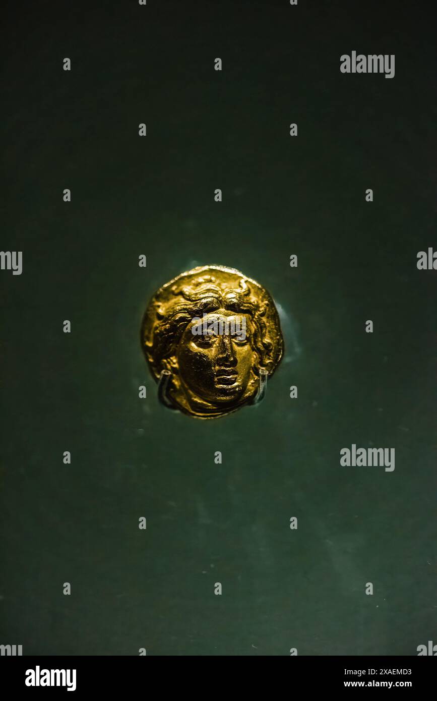 This image shows an ancient gold coin with a profile of a female head ...