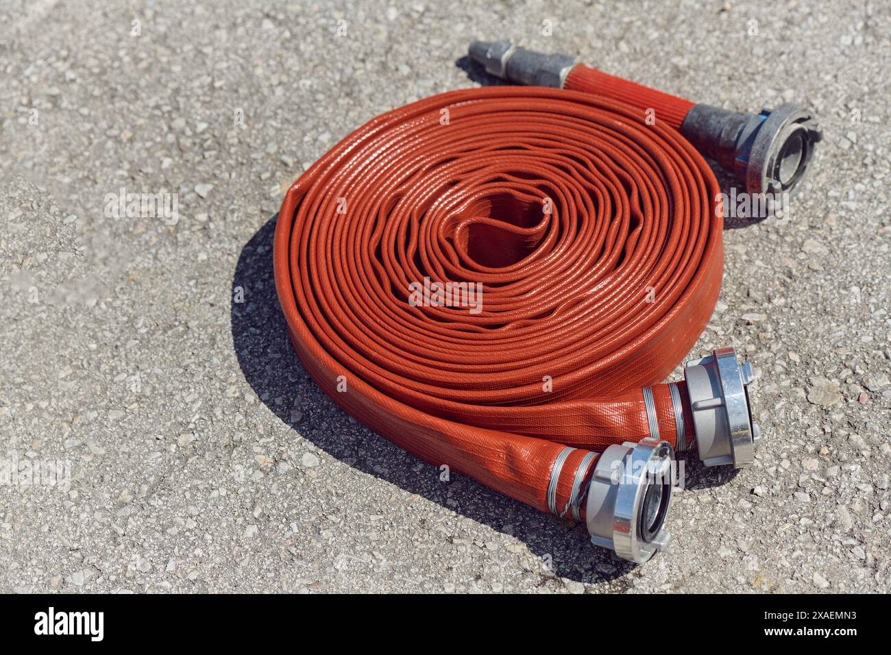 Coiled Fire Hose Ready for Action on the Ground Stock Photo - Alamy
